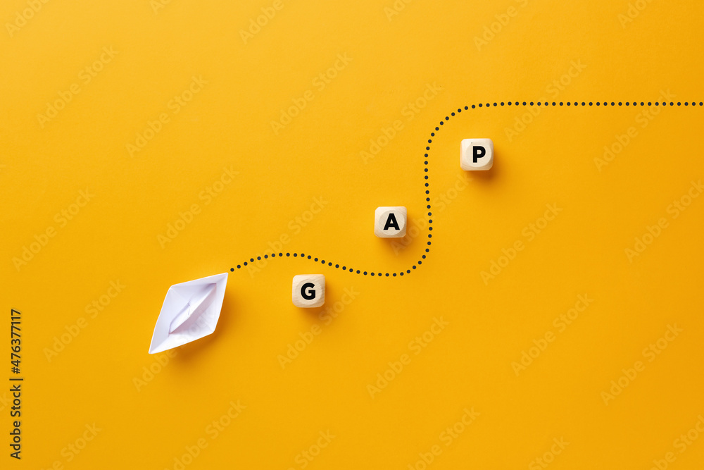 Origami paper boat passes through the wooden cube barriers with the ...