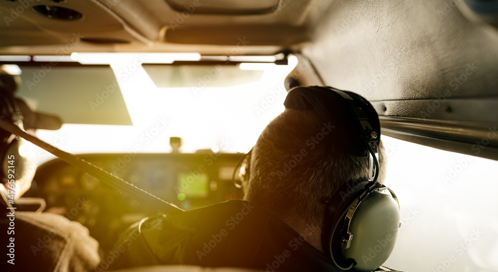 Rear view of pilot and copilot in private cockpit of small airplane ...