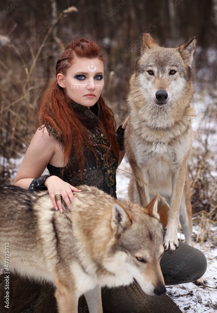 Female viking in warrior dress with two wolves in winter. Fantasy ...