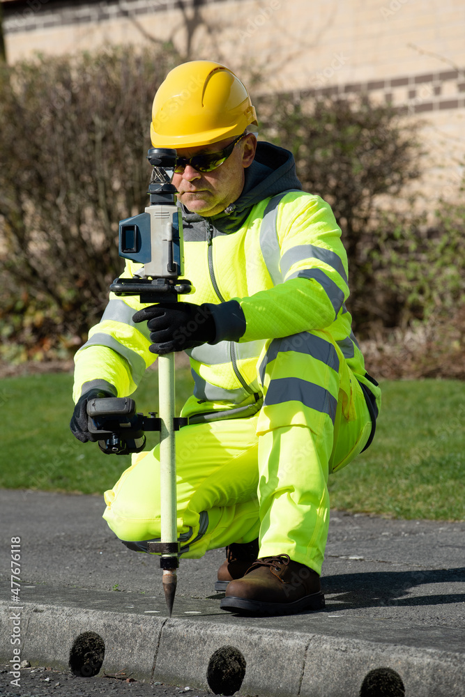 Site engineer doing road survey using modern robotic total station EDM ...