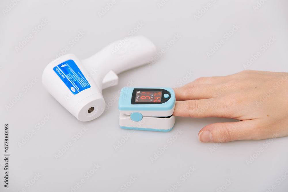 Pulse oximeter and thermometer gun on white background. Measuring ...