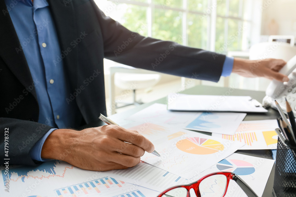 Businessman working with diagrams at desk in office, closeup Stock ...