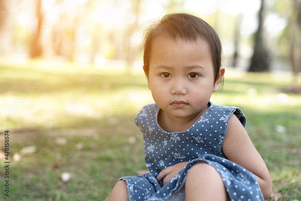 Young Little Asian kid sitting on grass outdoor park depressed and ...