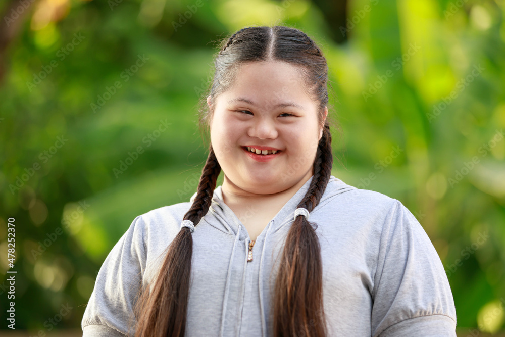 Portrait shot of Asian young chubby down syndrome autistic autism little cute schoolgirl with ...