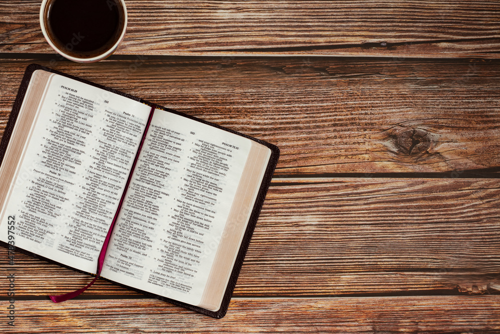 Open Holy Bible Book on wooden table background with a cup of coffee ...