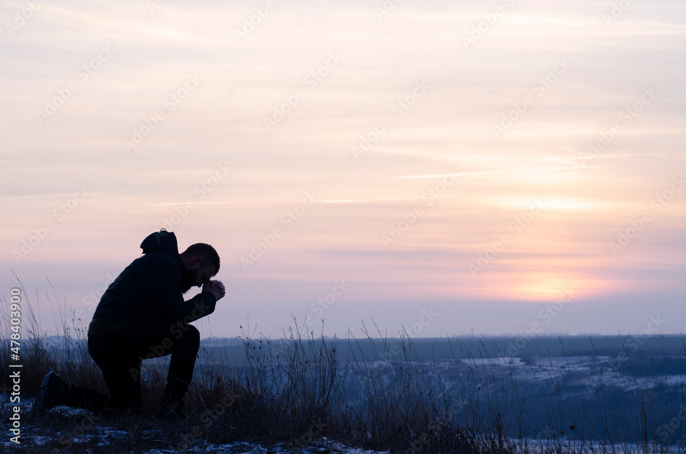 Pray. Repentance. Silhouetted men on a background of blue sky and ...