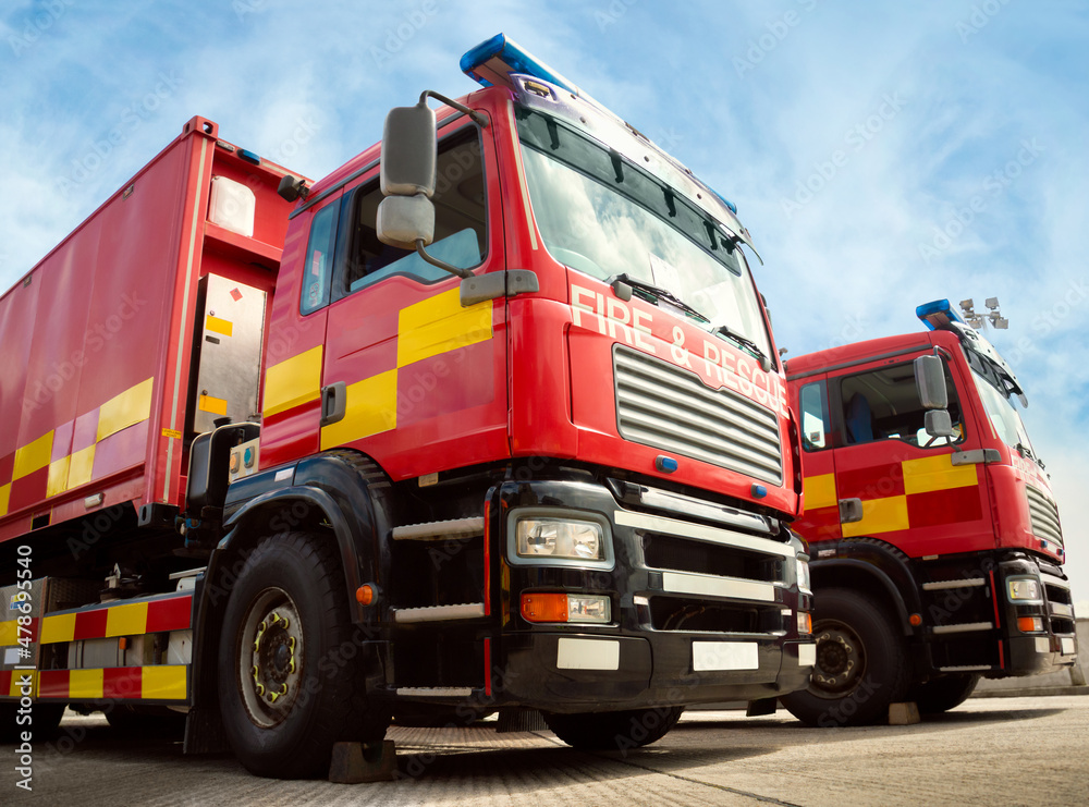 Two red fire truck emergency vehicles. The fire engines carry ladders ...