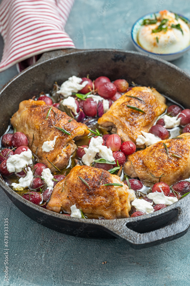 Chicken thighs braised on grapes in cast iron skillet の Stock フォト ...