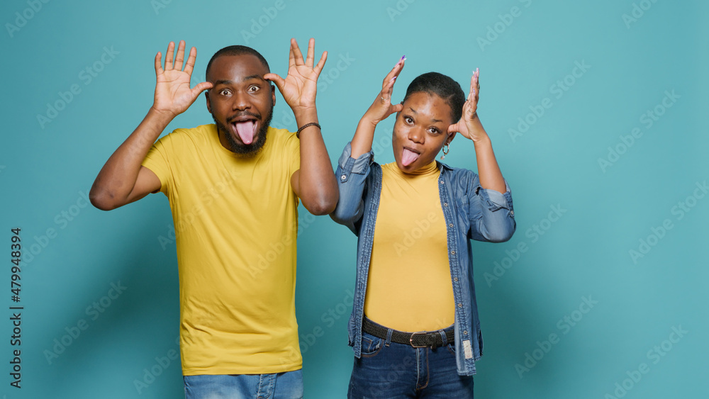 Man and woman sticking tongue out and fooling around in front of camera ...