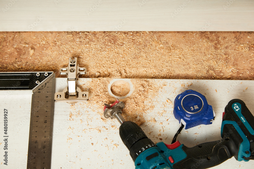 Installation of furniture hinges in the kitchen cabinet door. Tools and ...