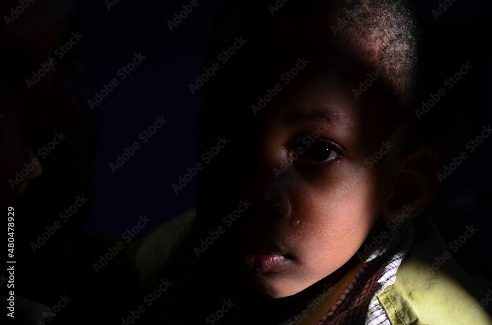 little boy crying with tears running down his cheek, the little boy is ...