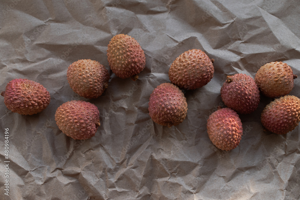 Exotic fruits lie horizontally in a strip on crumpled craft paper ...