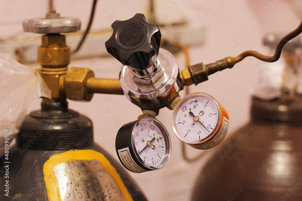 A gas cylinder with nitrogen, a gas reducer and two pressure gauges ...