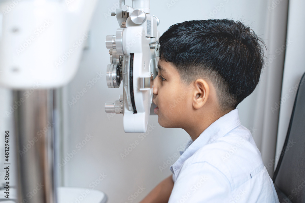 Indian boy doing eye test checking examination with optometrist in ...