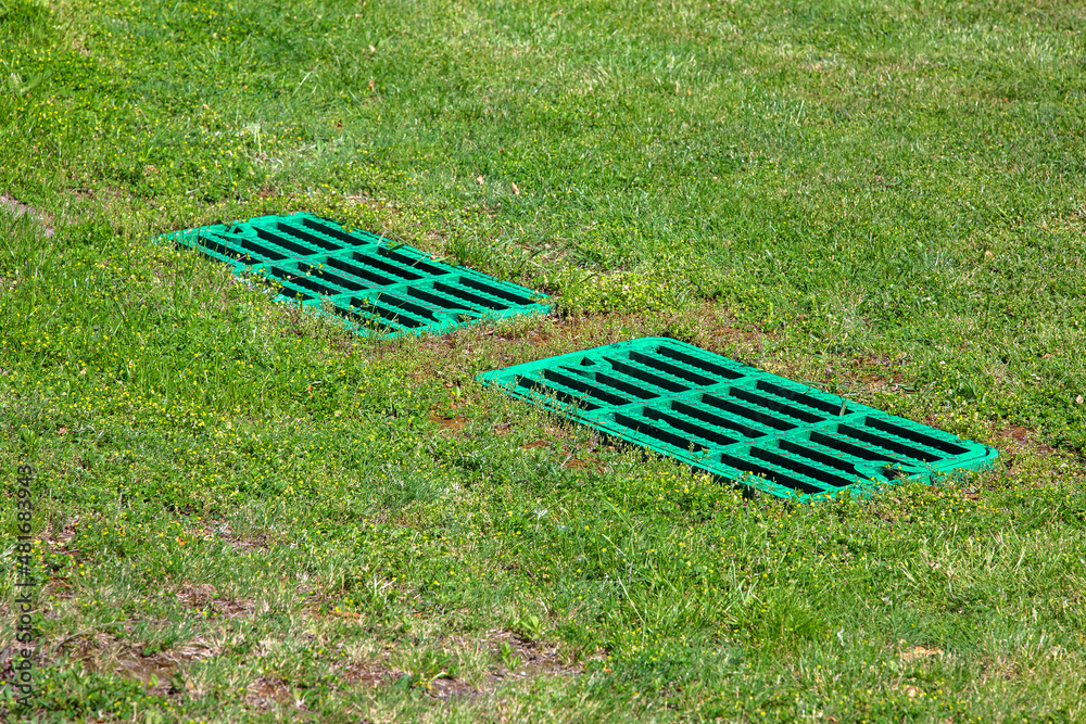 catch basin grate drainage on the lawn with green grass septic tank ...