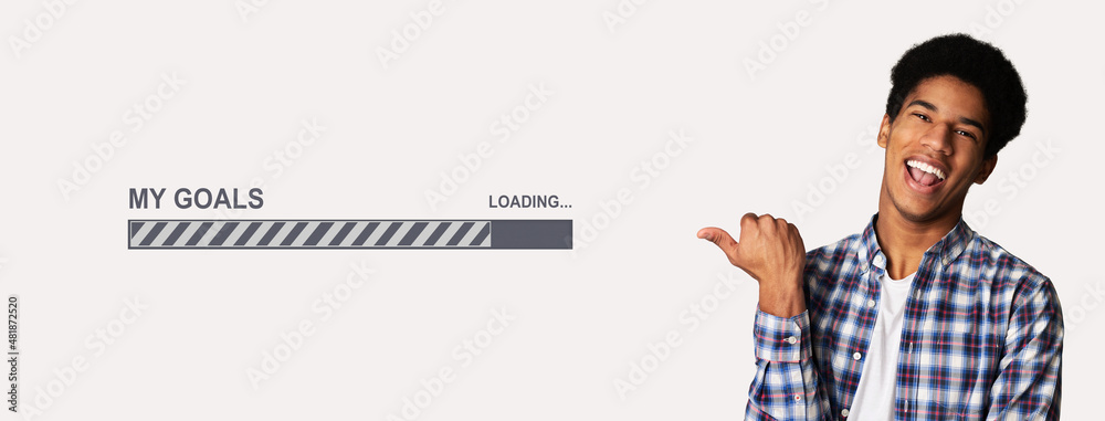 Cheerful black teenage guy pointing aside at MY GOALS loading process ...