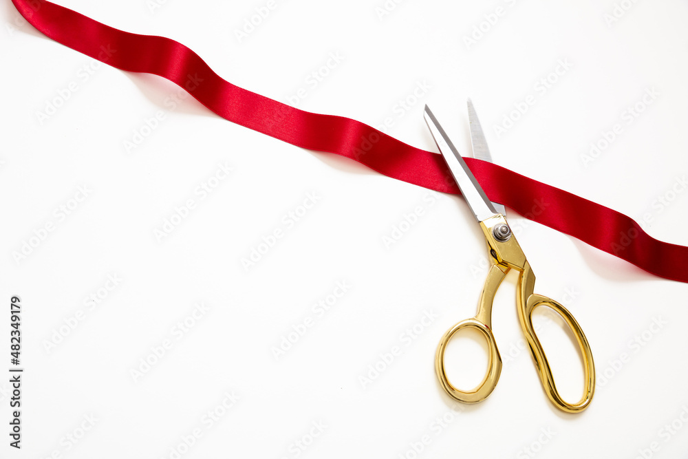 Grand opening, ribbon cut, overhead of gold scissors and red satin ...