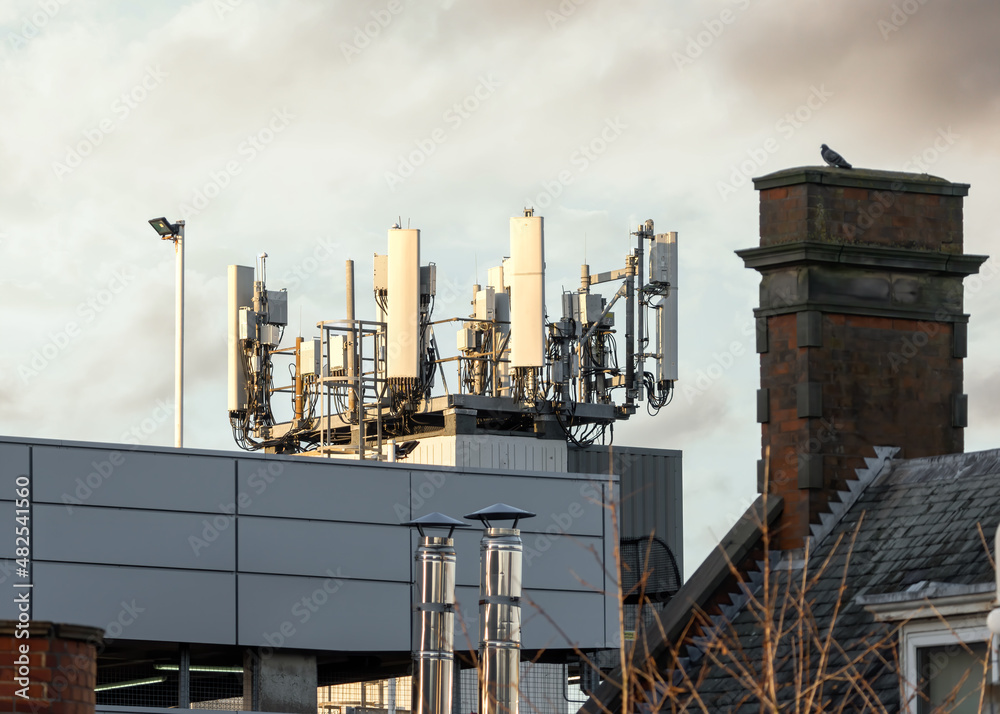 5g mobile phone radio mast transmitter at sunset in residential town ...