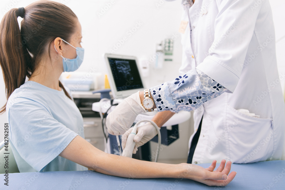 Doctor doing the ultrasound on the hand close up. Doctor demonstrates ...