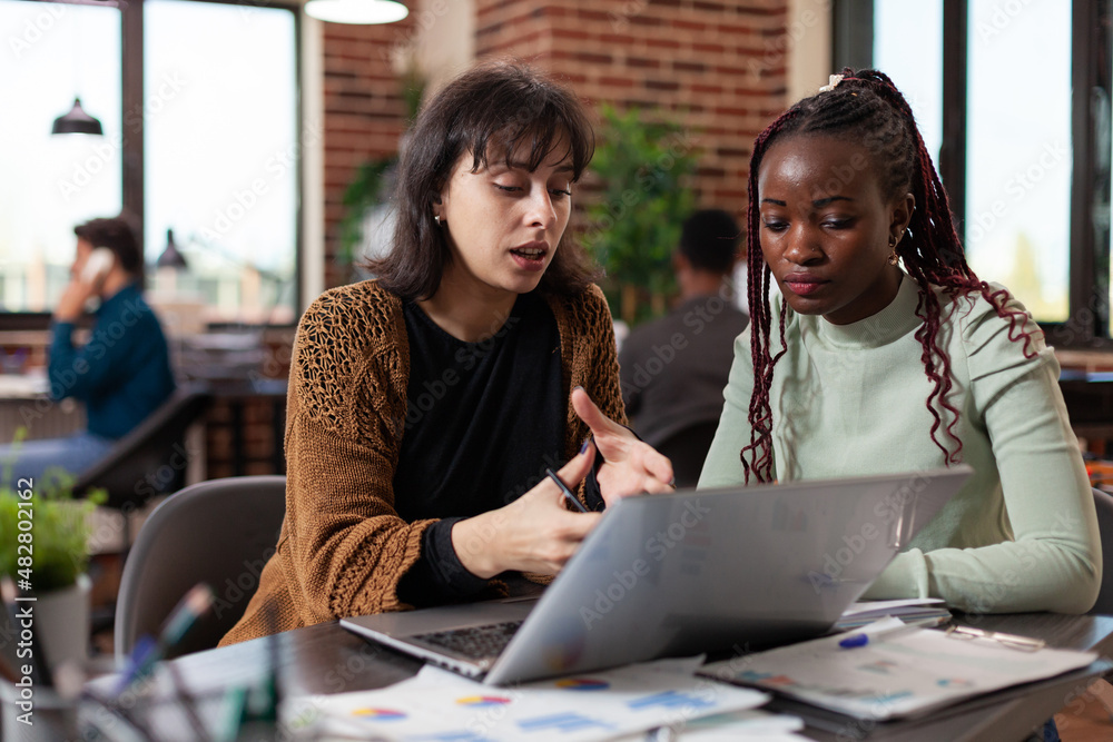 Multiracial businesswomen working at financial project analyzing ...