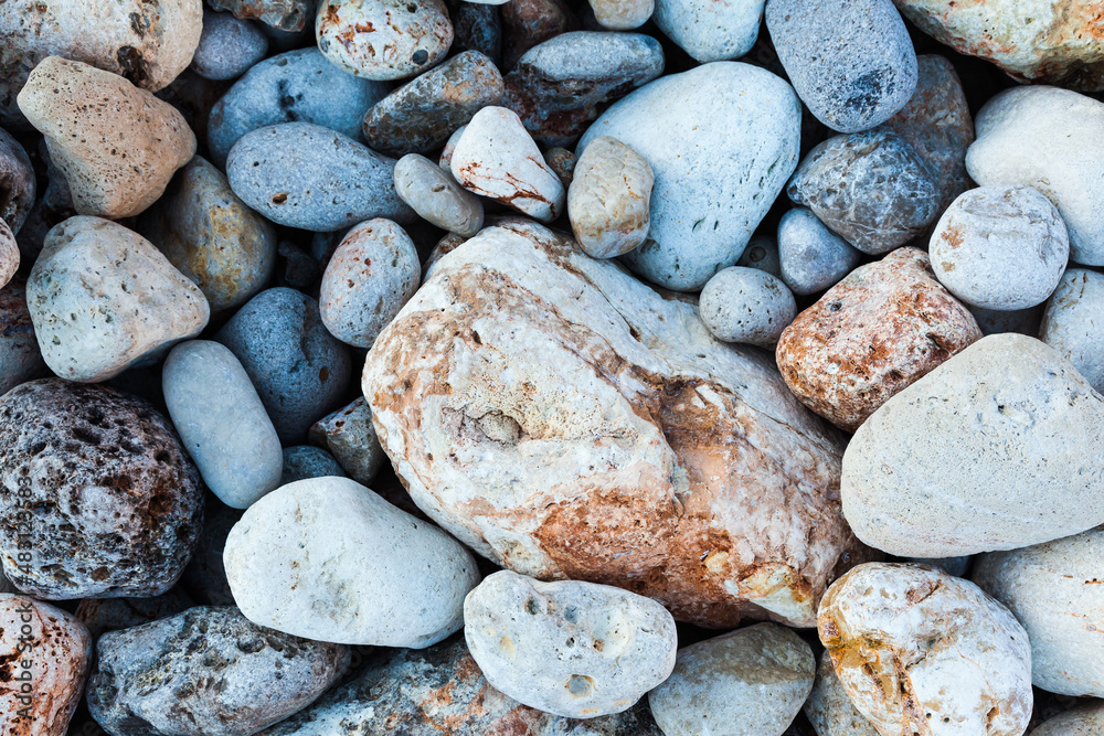 Stones of different shapes, sizes and colors on the seashore, close-up ...