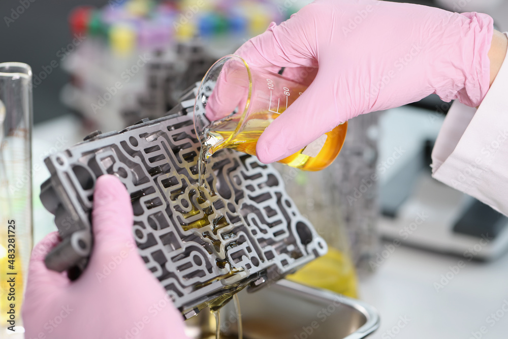 Mechanic man pouring liquid purified oil on automobile part Stock Photo ...