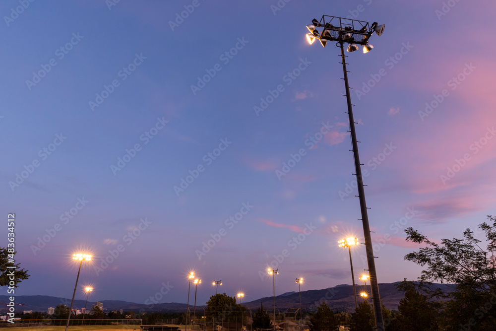 Tall stadium light pole over a baseball field at sunset Stock Photo ...