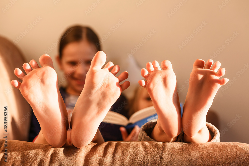 Children feet barefoot at home. Kids Sisters have fun playing with ...