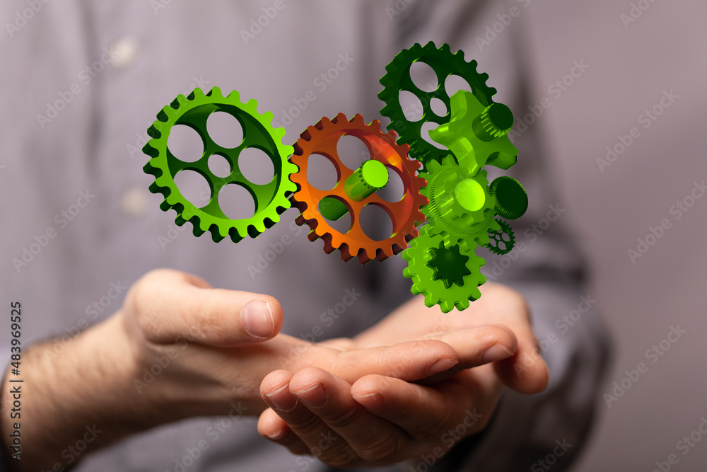 Mechanism, green metallic gears and cogs at work on brown background ...