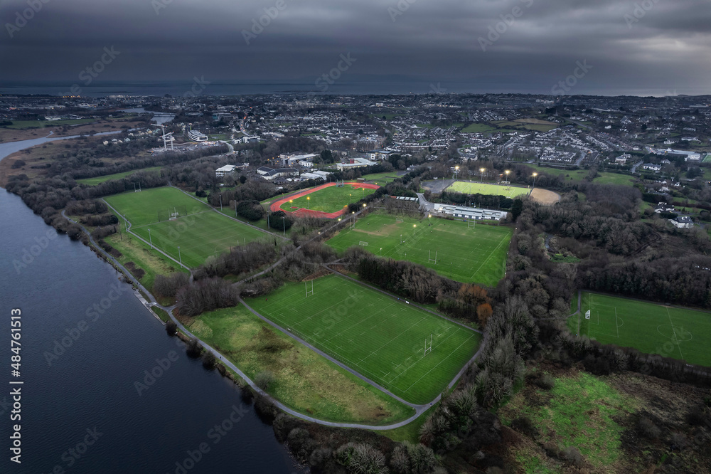 River Corrib flows into Galway city, aerial view. Sport ground with ...