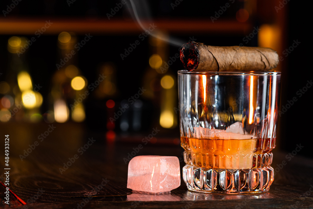 Cigar, elegant glass of brandy on the bar counter. Alcoholic drinks ...