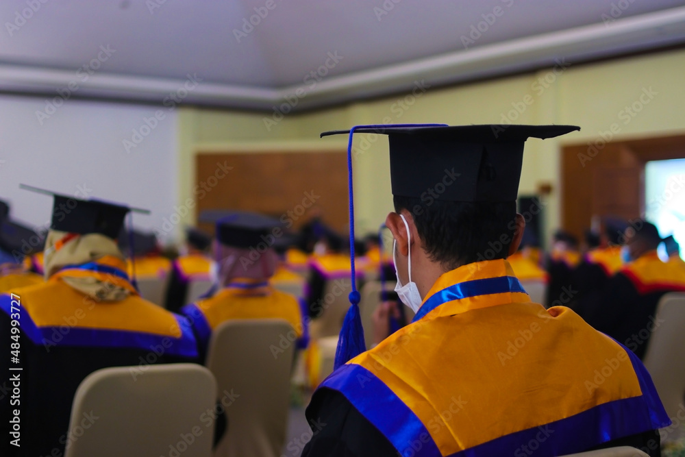 Back view of graduates students wearing mask is attending the ...