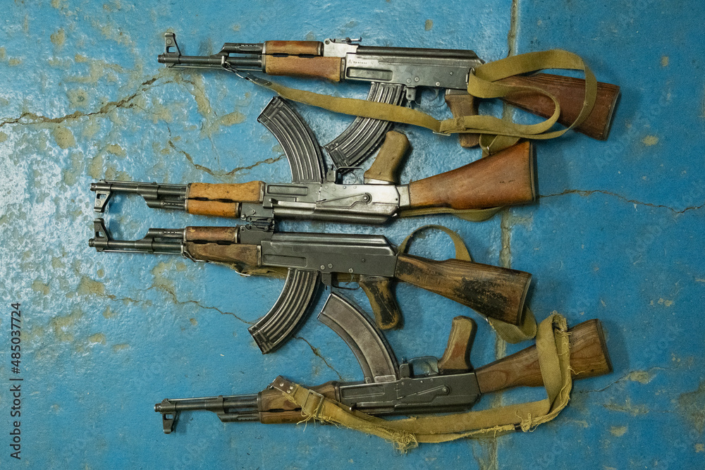Old AK-47 machine guns on a concrete floor. Kalashnikov assault rifles ...