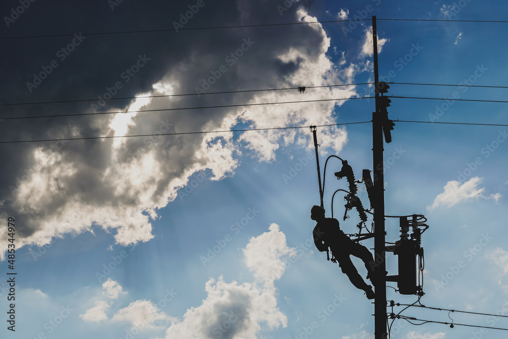 The silhouette of power lineman replacing a transformer and hotline ...