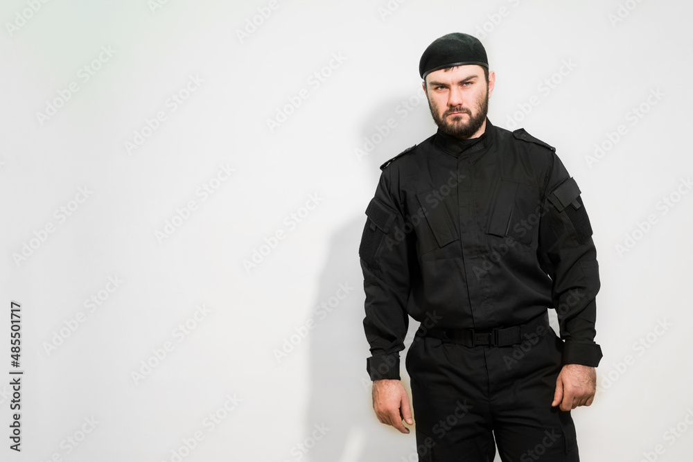 Security guard man in black uniform with a baton in his hands on a ...