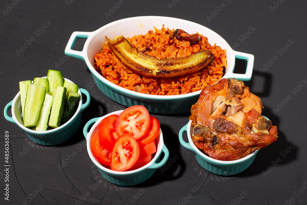 Jollof rice with fried banana, baked chicken. Rice with tomatoes ...