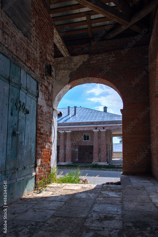 View through the brick arch to the building of the shopping mall with ...