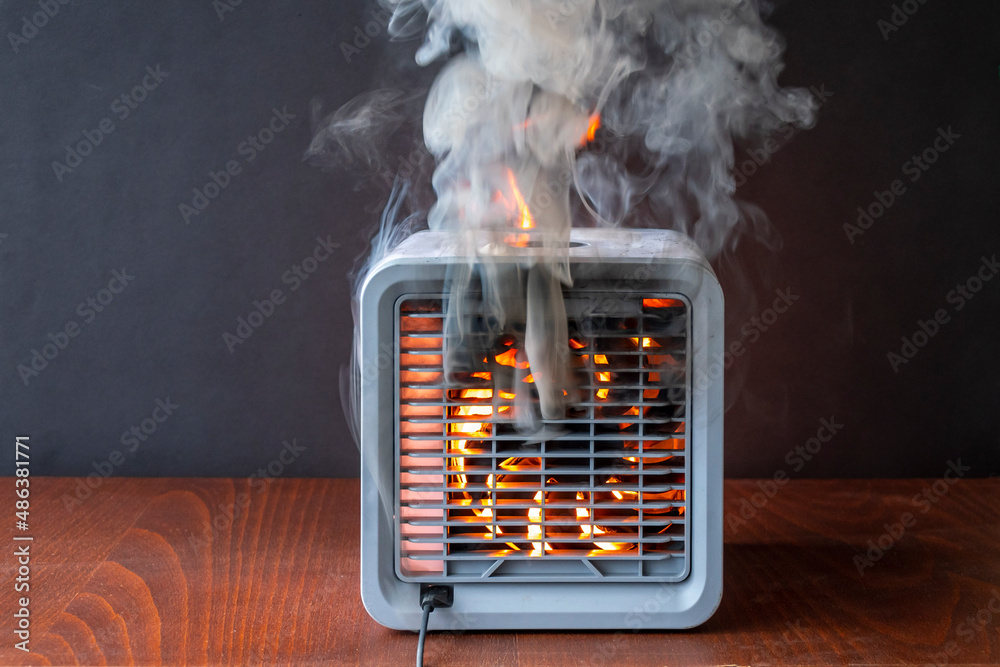 Air purifier burns with fire flames and sparks black smoke. The cause of the fire in the apartment a short circuit faulty equipment. Stock Photo Adobe Stock