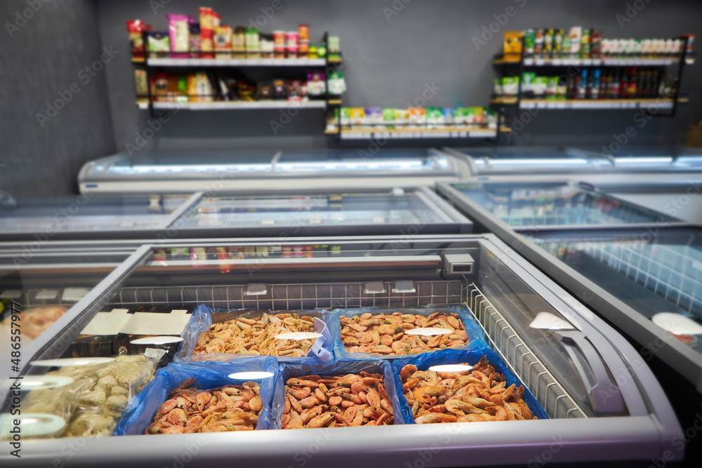 Frozen shrimp in the window of a fish store in the refrigerator ...