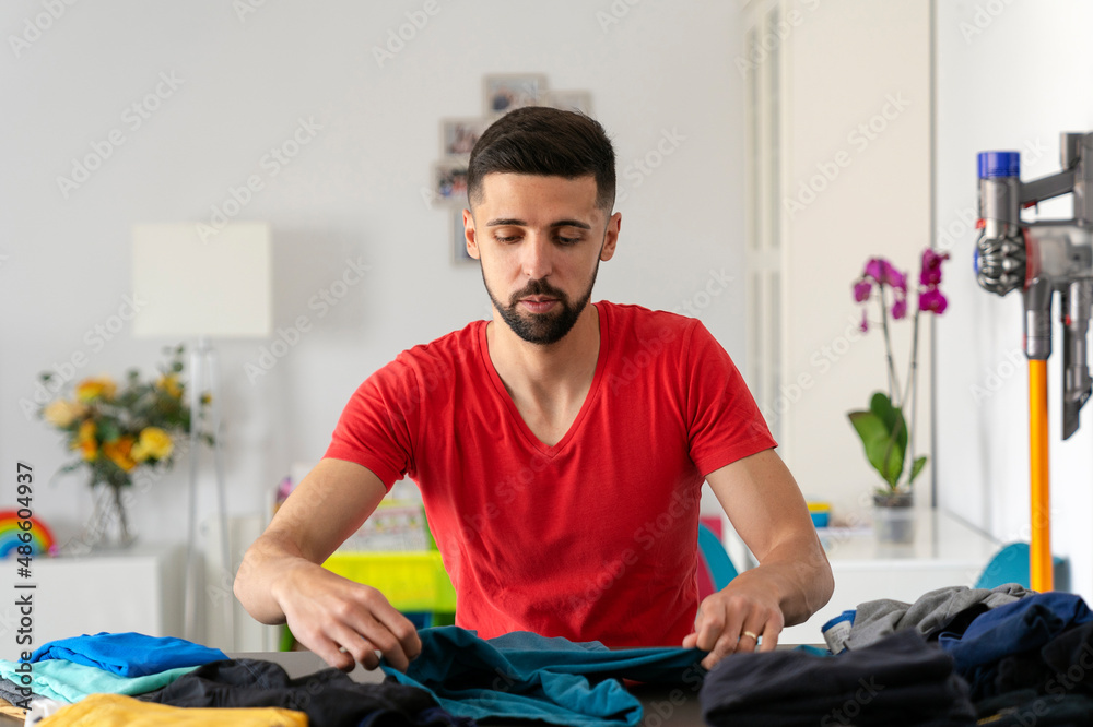 adult male folding clothes carefully on a table Stock Photo | Adobe Stock