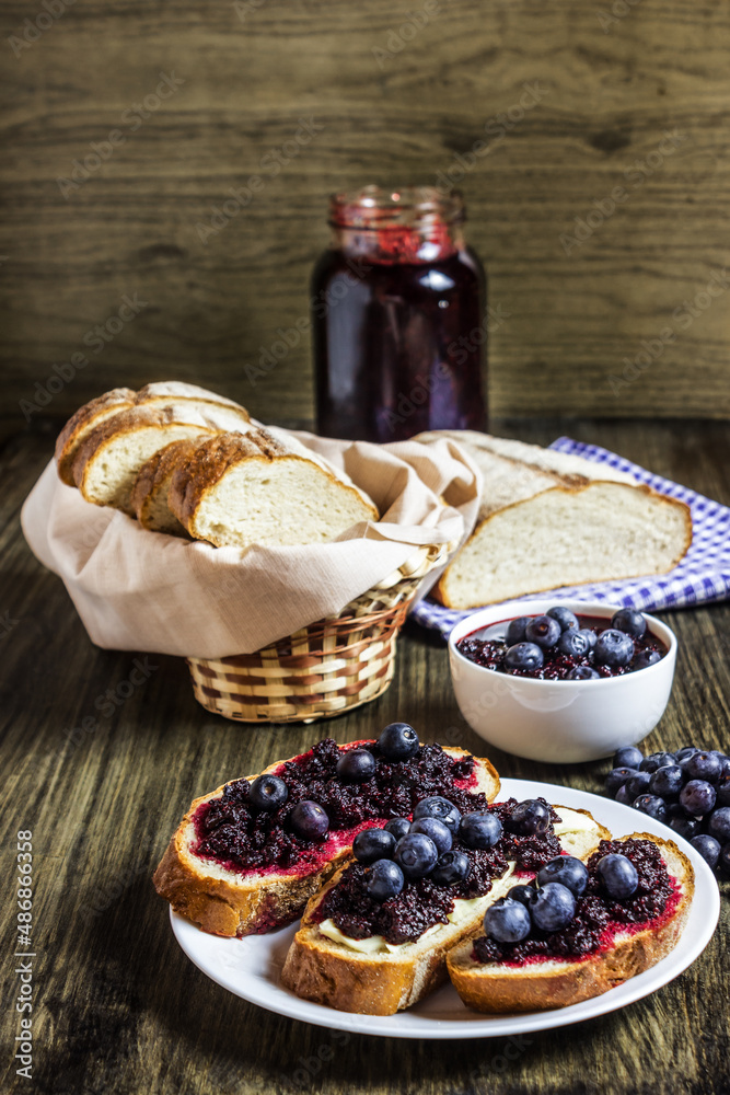 Sweet sandwiches with homemade blueberry jam. Jam in a jar and a bowl ...