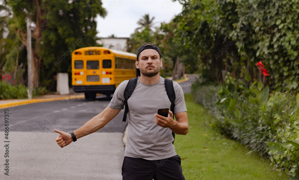 Hitchhiker with thumb up catching a car, the young man missed the bus ...