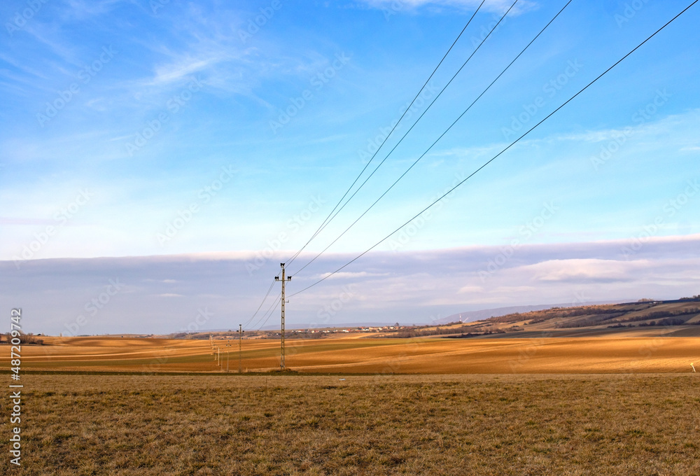 Rural field with a high-voltage pole line crossing the landscape Stock ...
