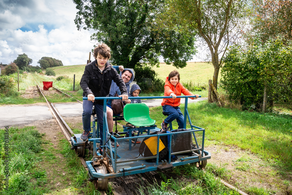 Family enjoying the rail bike attraction in France, Normandy. Father ...