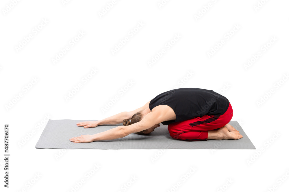 Male yoga, childs pose. Athletic Caucasian man with blond hair in a bun ...