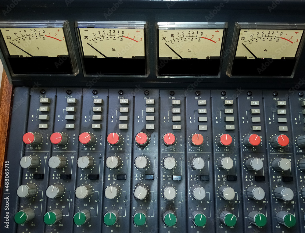 VU meters x 4 on a analogue mixing console channels showing knobs eq ...