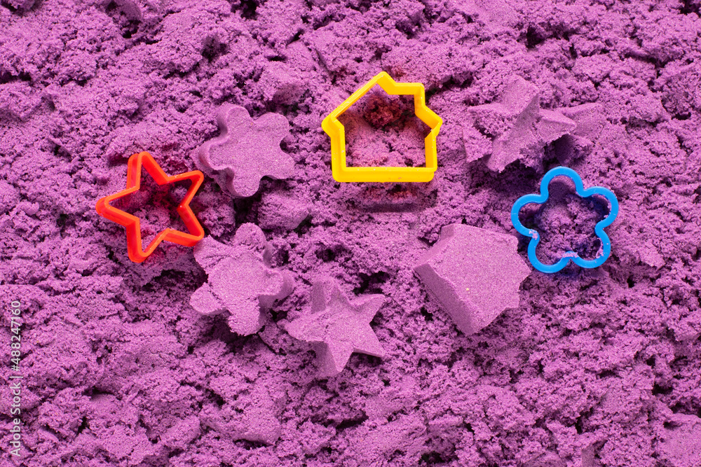 Molds and figures molded from kinetic sand in the form of a house, a ...