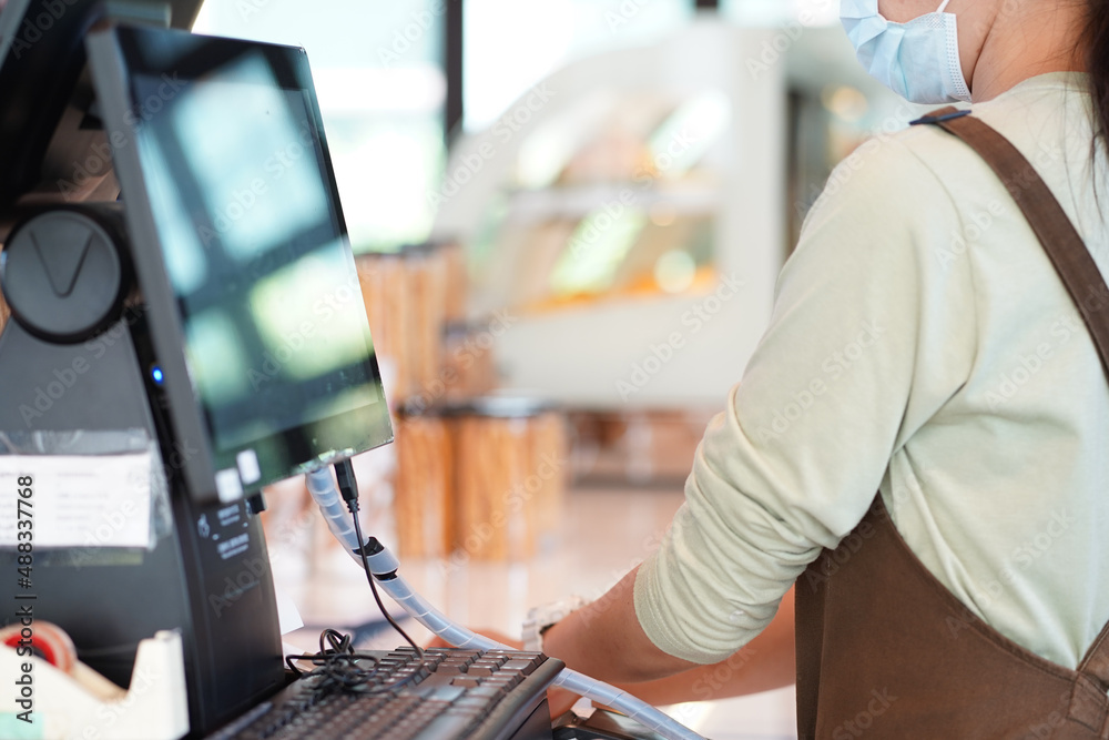 Close up woman cashier using cash register screen to check and pay ...