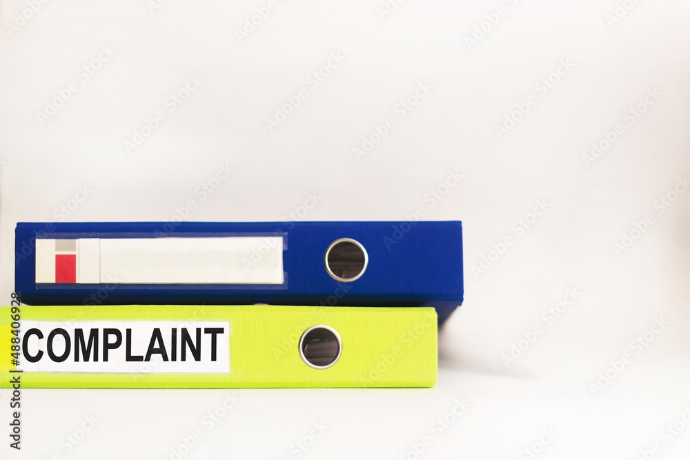 complaint words on a label with a folder for documents on a white ...