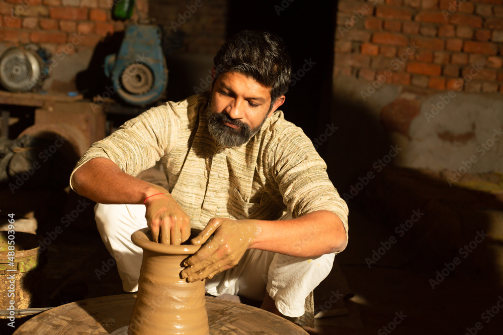 Indian male pottery maker building a clay pot, Beard man worker or ...